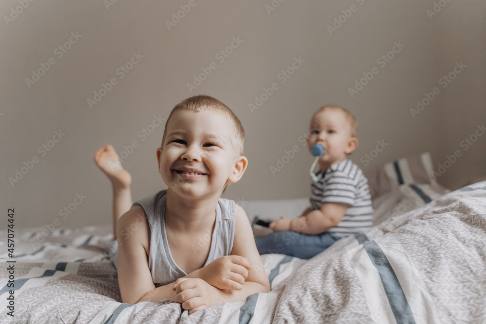 Foto de Two baby brothers are sitting on the bed. One child is 4 years ...