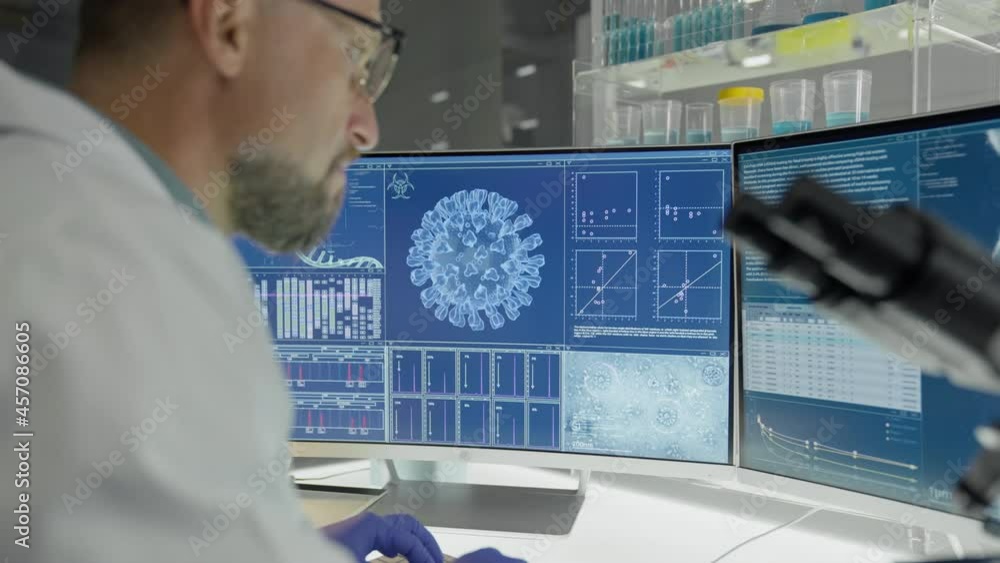 Coronavirus model on computer screen. Scientitst making notes ...