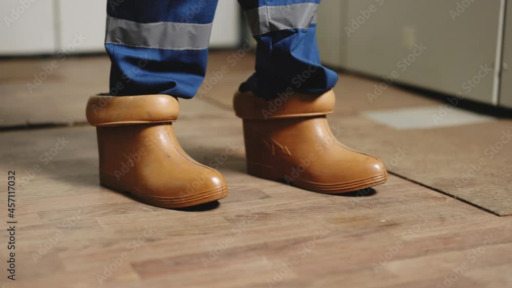 Electrical technician is putting on special protective shoes in power ...