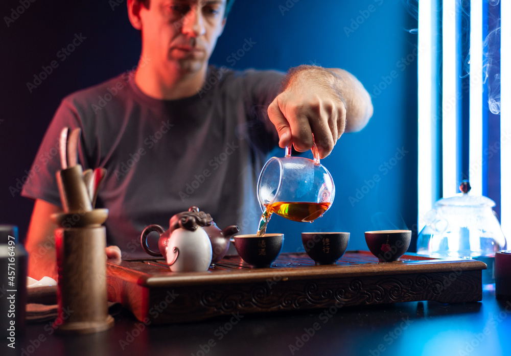 a man makes tea at a tea table with appliances according to the ...