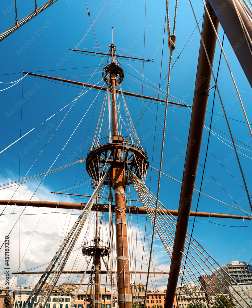 The masts of a large sailing ship without sails against the blue sky ...