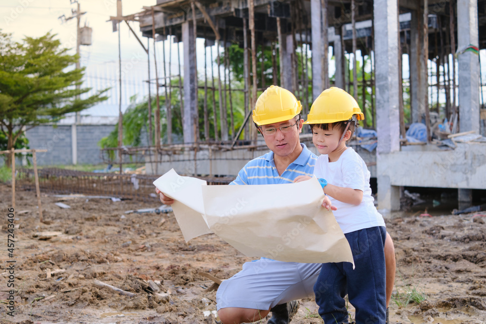 Smiling happy Asian Dad and son wearing yellow construction helmet or ...