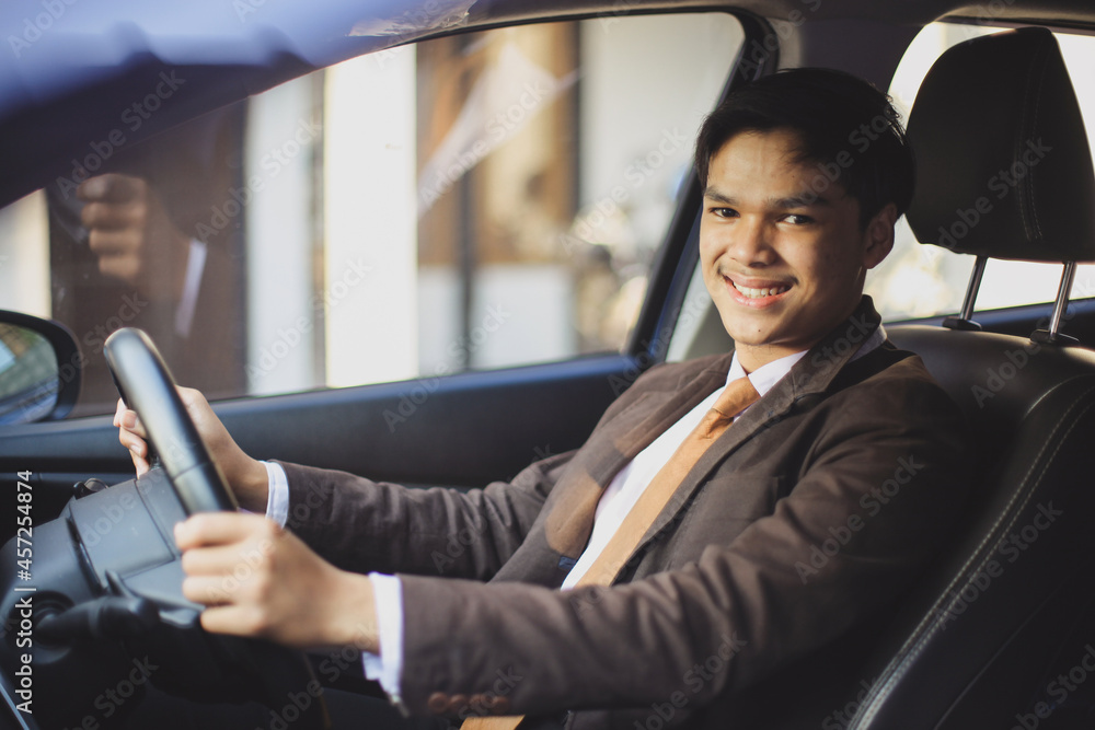 Asian businessman is driving a car while smiling to the camera Stock ...