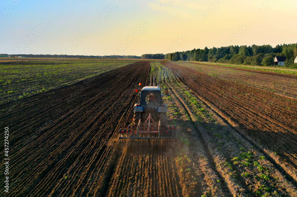 Tractor on cultivating field work. Soil Tillage in farmers country ...