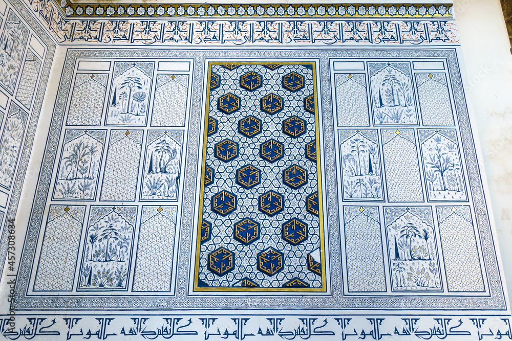 Ancient wall decorated with medieval oriental patterns in white and ...