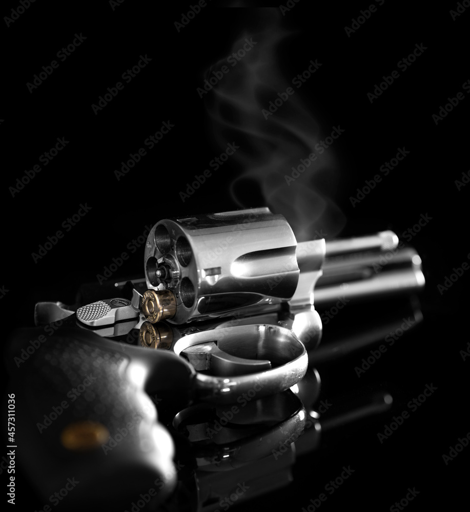 Chrome revolver with tilted drum after firing single bullet. Russian ...