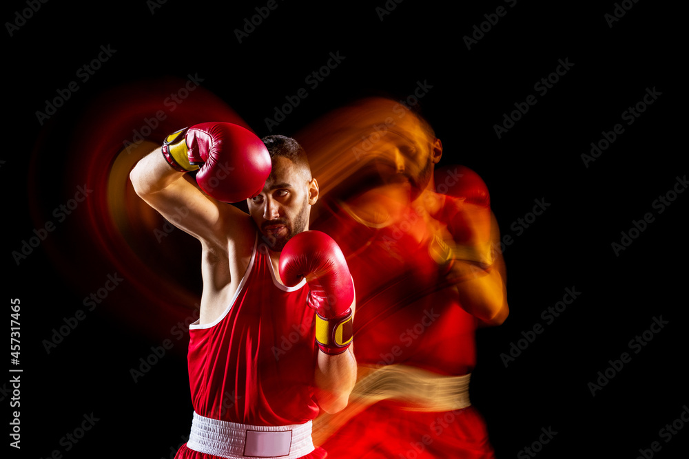 One professional male boxer training isolated over black backgrund in ...