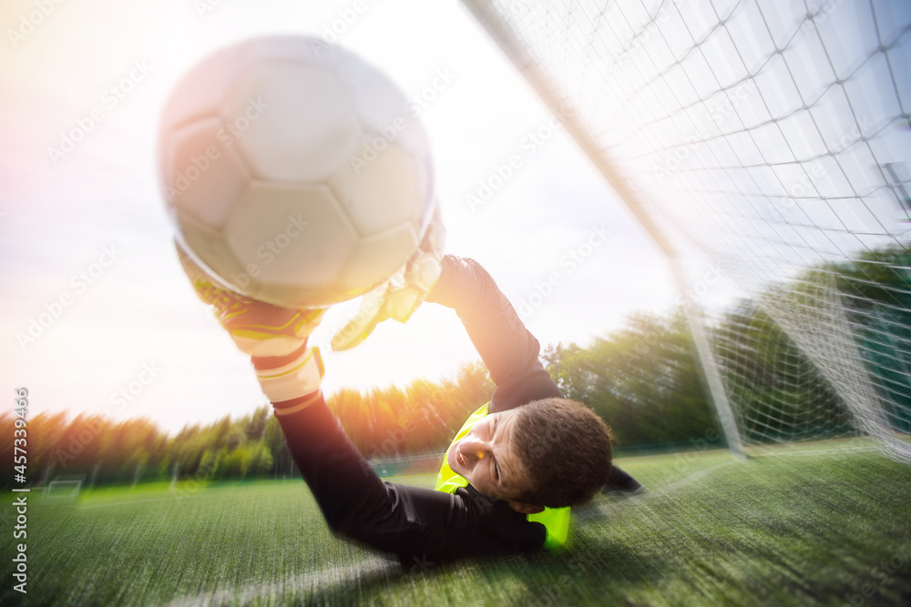 Goalkeeper soccer man catching ball in stadium, action moment of sport ...