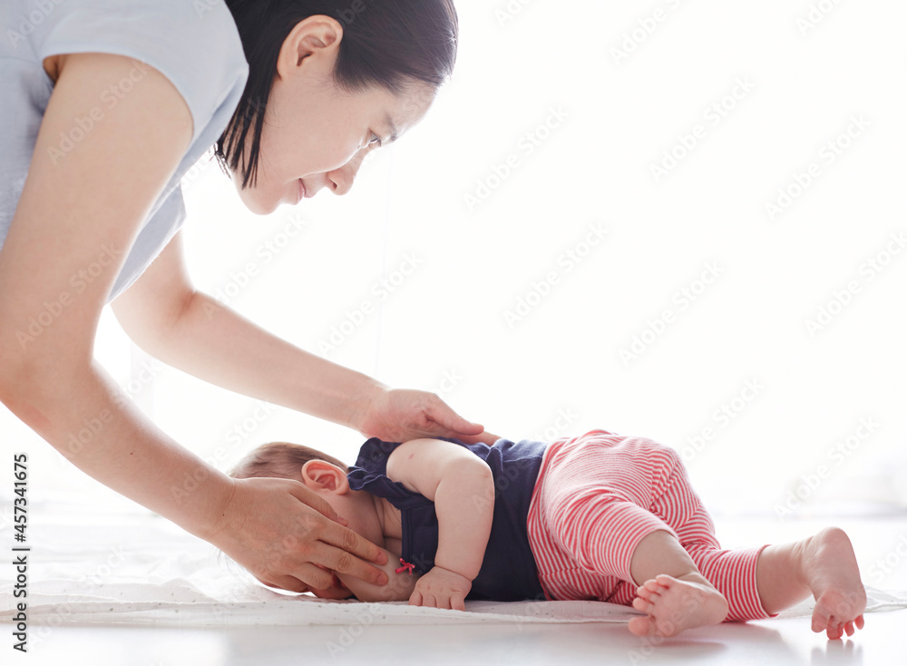 Cute Asian mom helps baby turn overCute Asian mom helps baby stand up ...