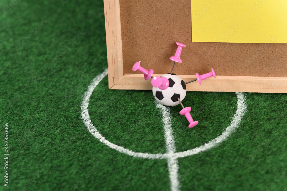 Soccer ball in the center of the soccer field and stationery push pins ...