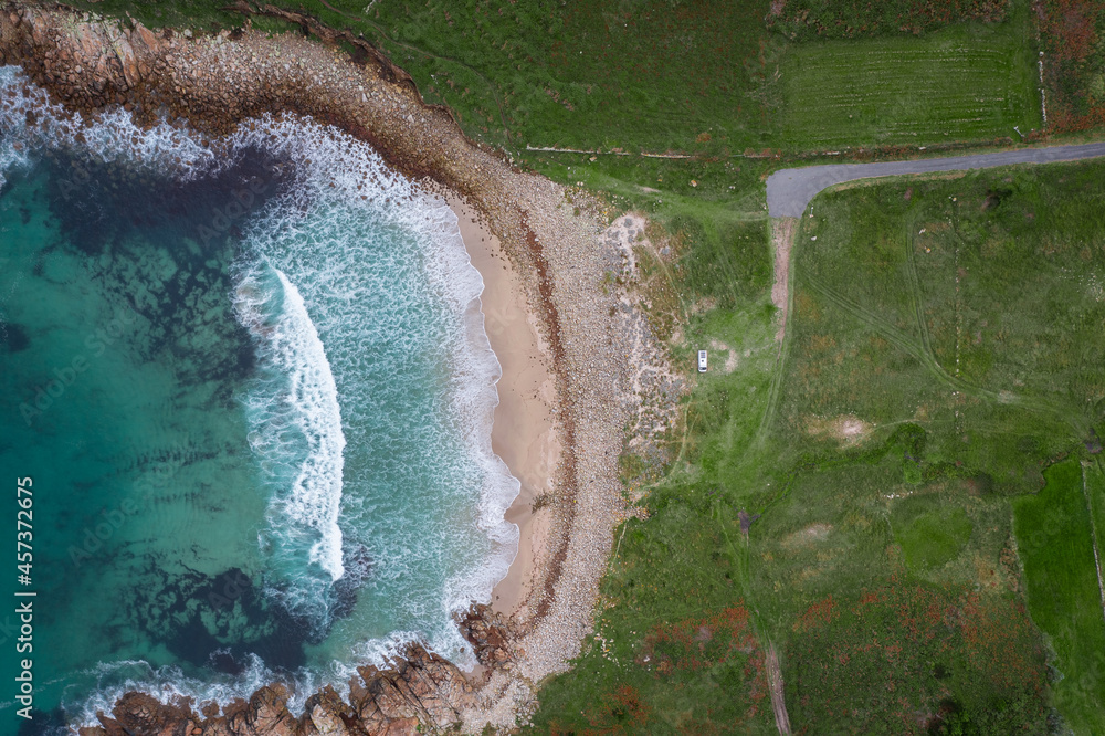 Drone top view of a camper van on a wild beach with green landscape ...