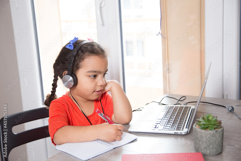 baby studying at home with his laptop and headphones . distance ...