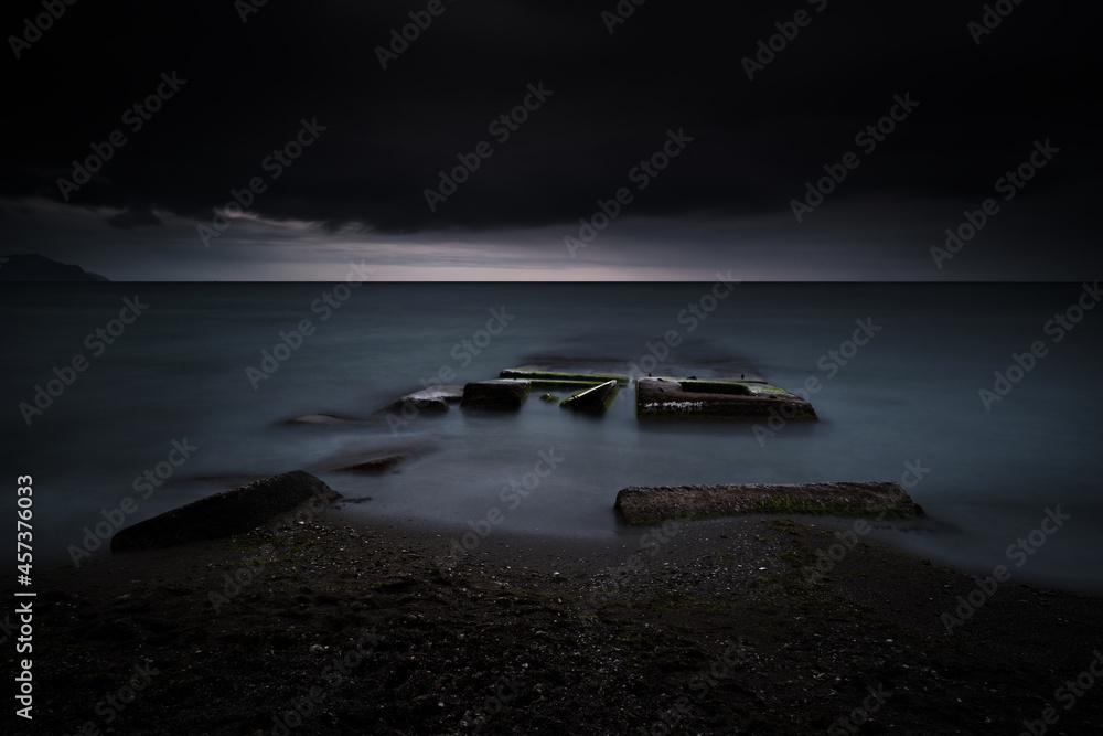 Dark Brooding Stone Slabs Immersed in Black Sea With Brooding Sky Stock ...