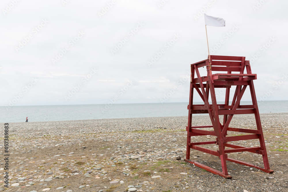 Red tower of lifeguards on a pebble beach in the resort town of Batumi ...