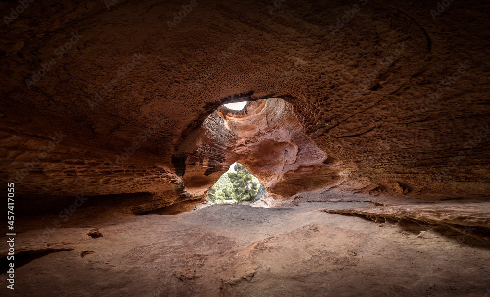 Image of a cave with a large entrance and a hole or window at the top ...