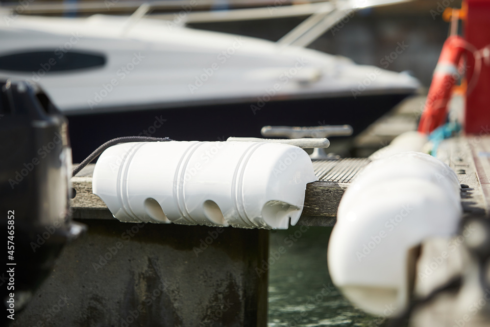 Long pier white fenders for a boat and dockside for protection ...
