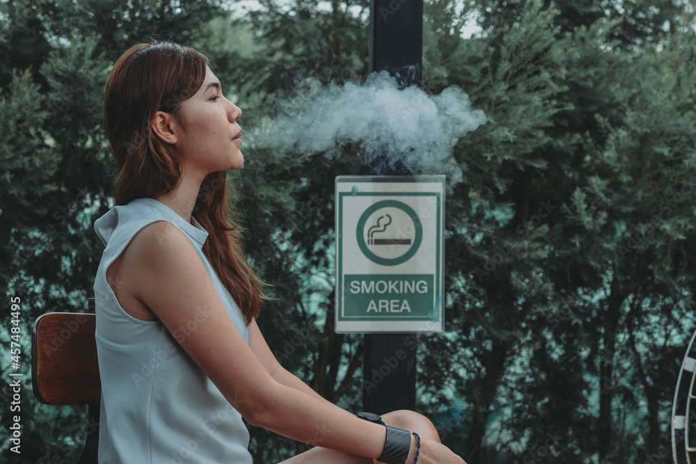Asian woman inhaling and cigarette vaping. Female secretly smoking in ...