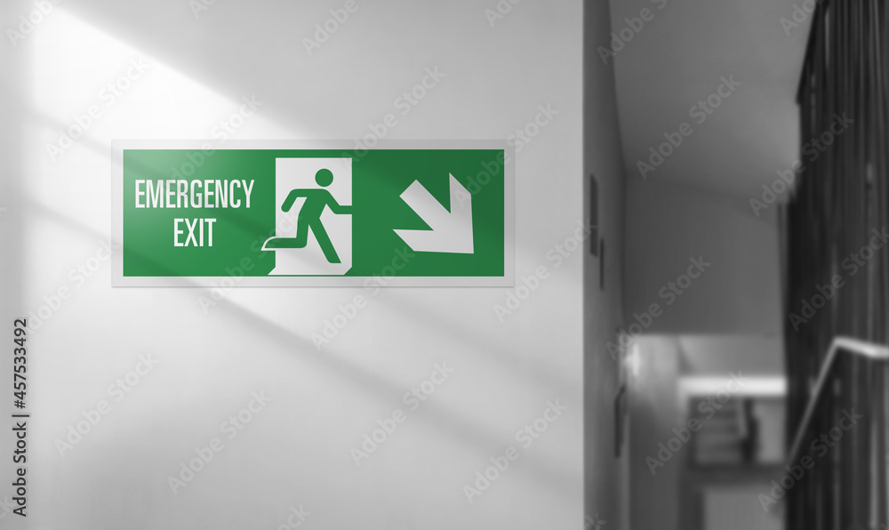 Emergency exit sign on a white wall. Interior with stairs. Stock Photo ...