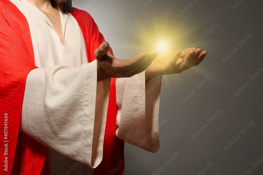 Jesus Christ on grey background, closeup. Miraculous light in hands ...