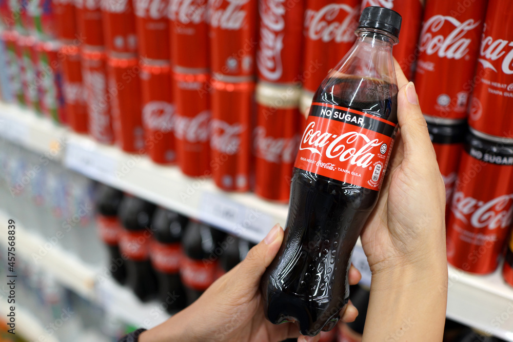 Hands Holding a bottle of Coca-Cola drink in a grocery store. Coca-Cola ...