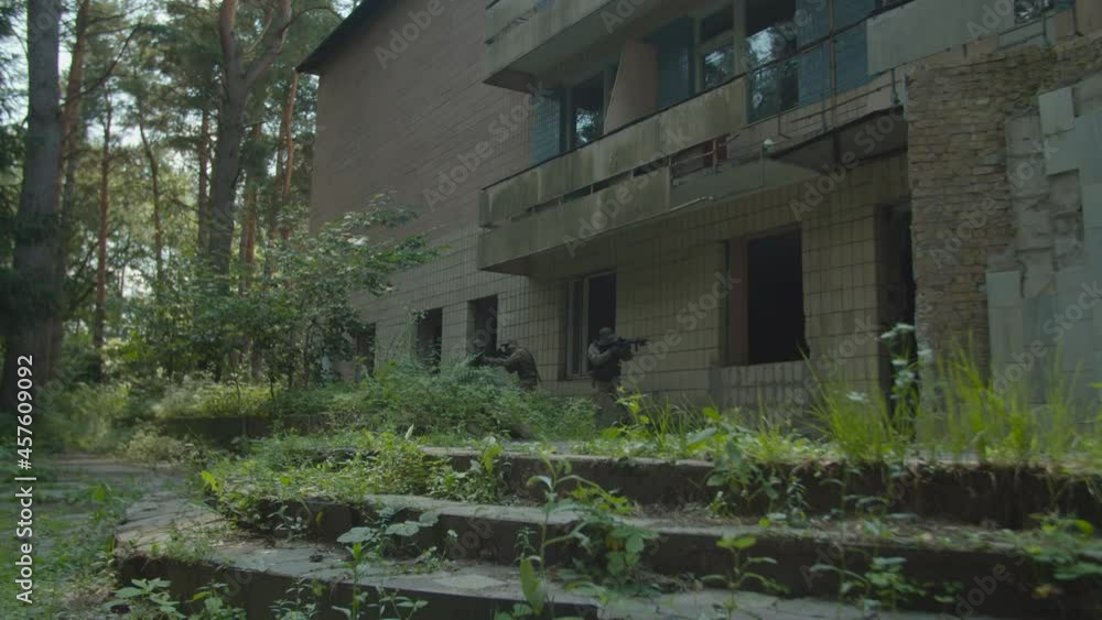 Counter-terrorist squad in combat gear leaving enemy building ...