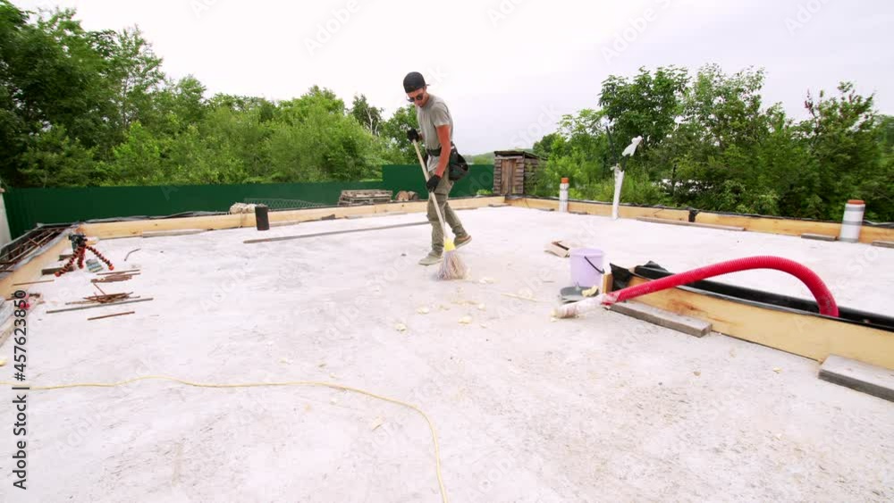 Timelapse of a builder sweeping the construction area with a broom. A ...