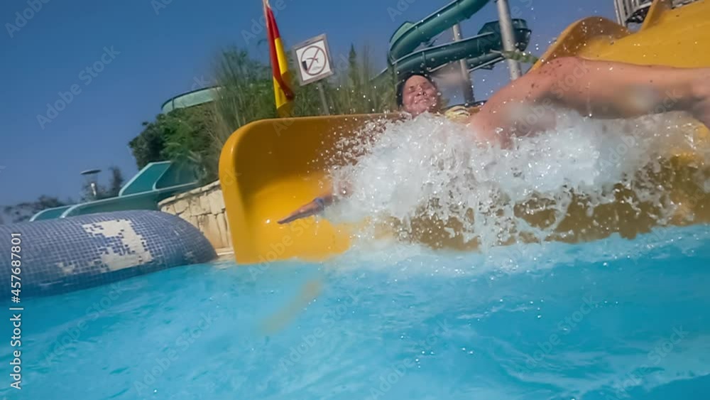 Descent from the waterslide on holiday aqua park. Slow motion on a ...