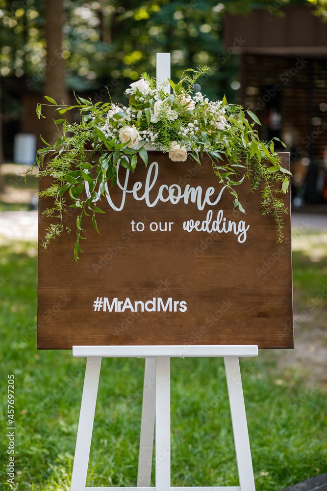 Wooden welcome table board sign at the wedding on the beach with ...