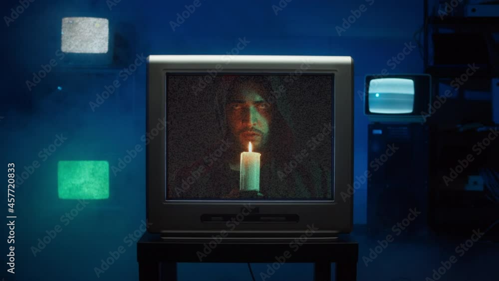 Old tv screen showing evil exorcist blowing with burning candle close ...