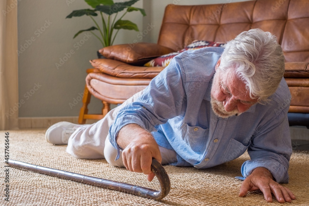 Elder senior man lying on floor after falling down with wooden walking ...