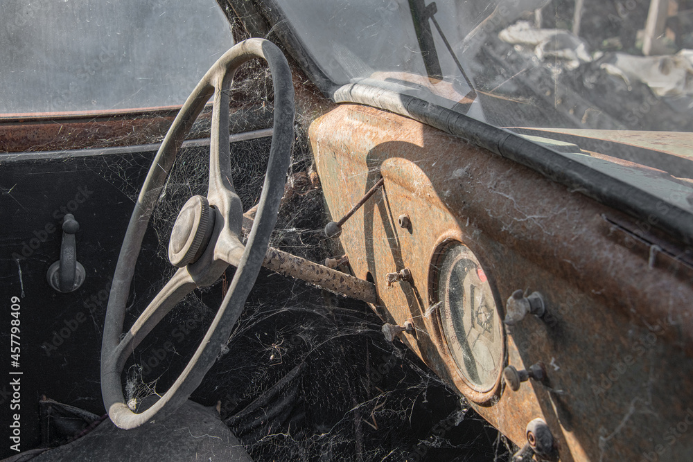 a close up image of an old retro rusty car. It is a left hand drive and ...