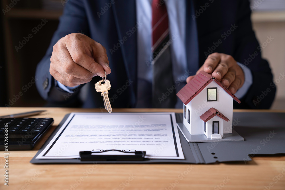Real estate agent hand over the keys during meeting after signing ...
