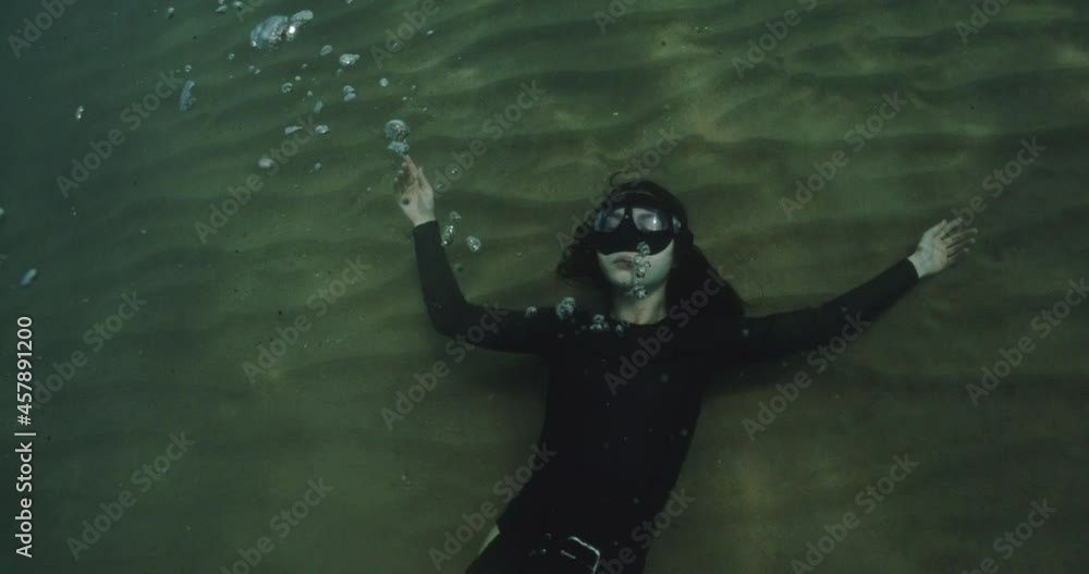 Diver woman lying underwater bottom, filmed on cinema camera. Brutal ...