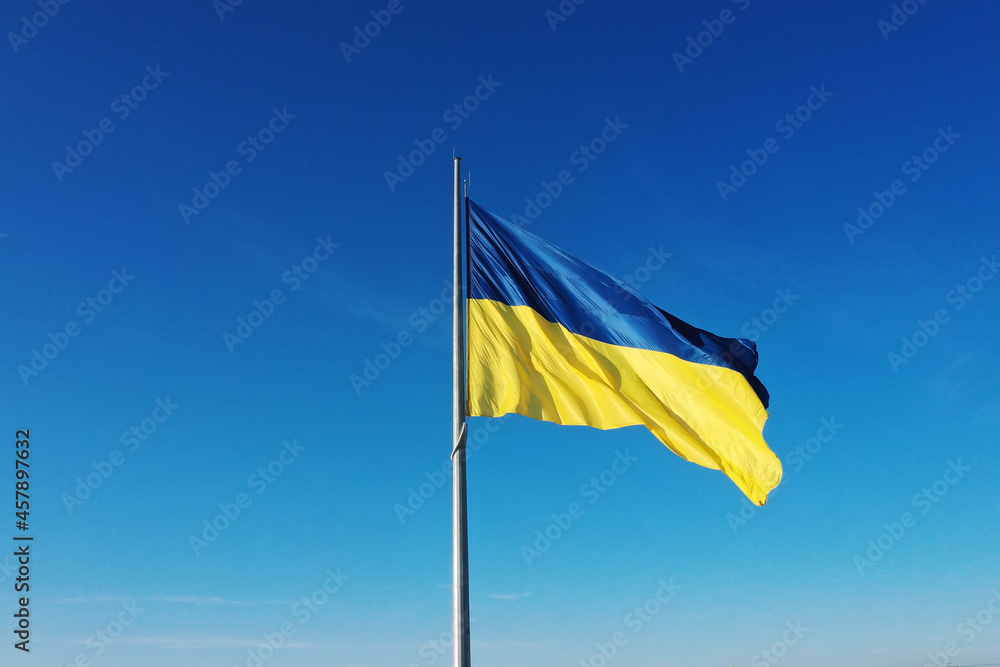 The flag of Ukraine develops on a flagpole against a background of ...