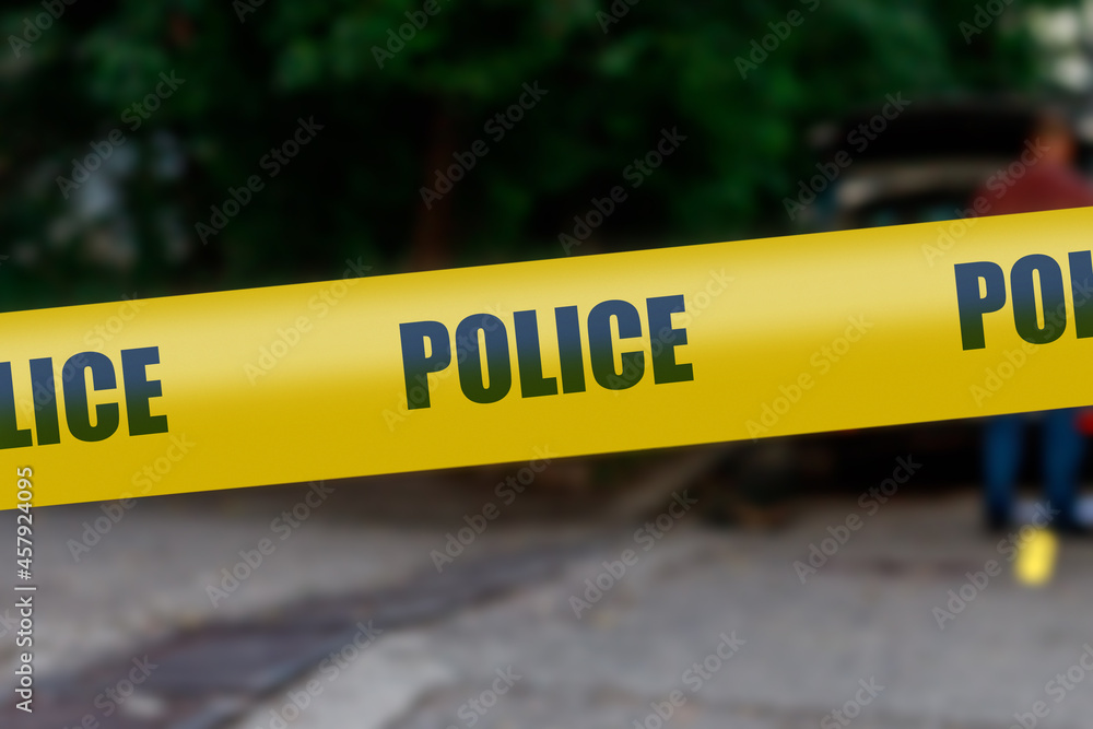 Yellow warning tape with the words Police on a blurred background of ...