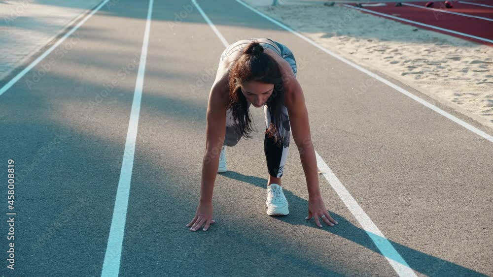 Female athlete on track. Young woman standing on start on stadium, then ...