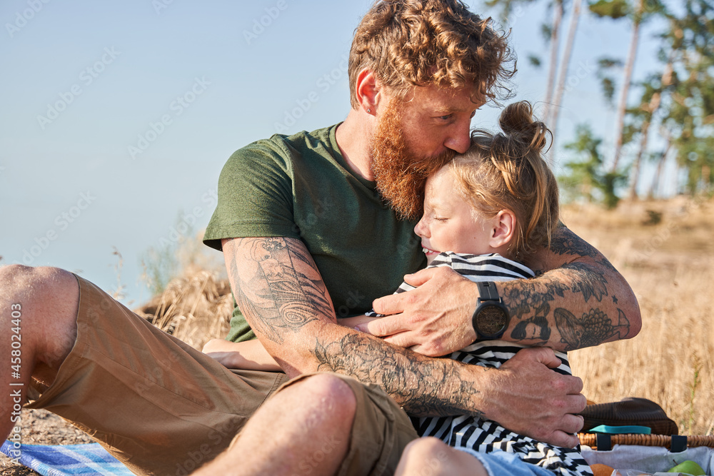 Man hugging and kissing his daughter on nature Stock Photo | Adobe Stock