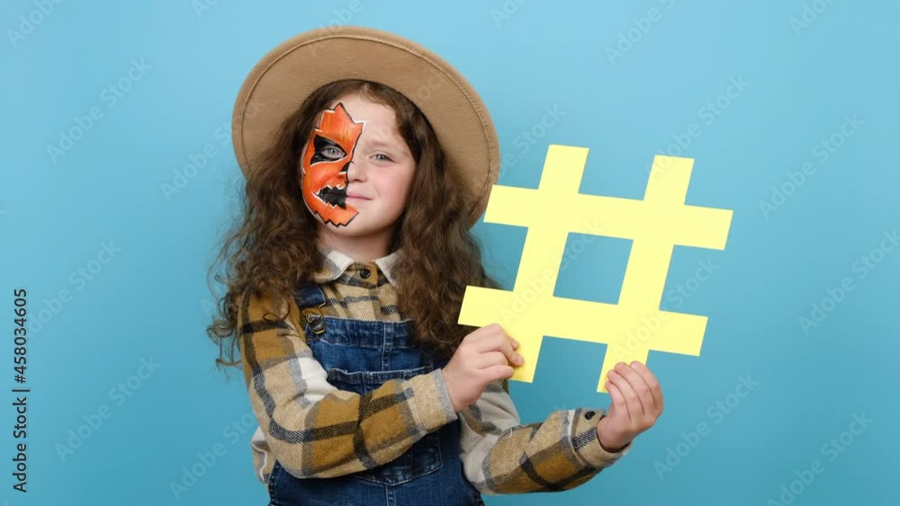 Adorable little girl kid with Halloween mask holding big white hashtag ...