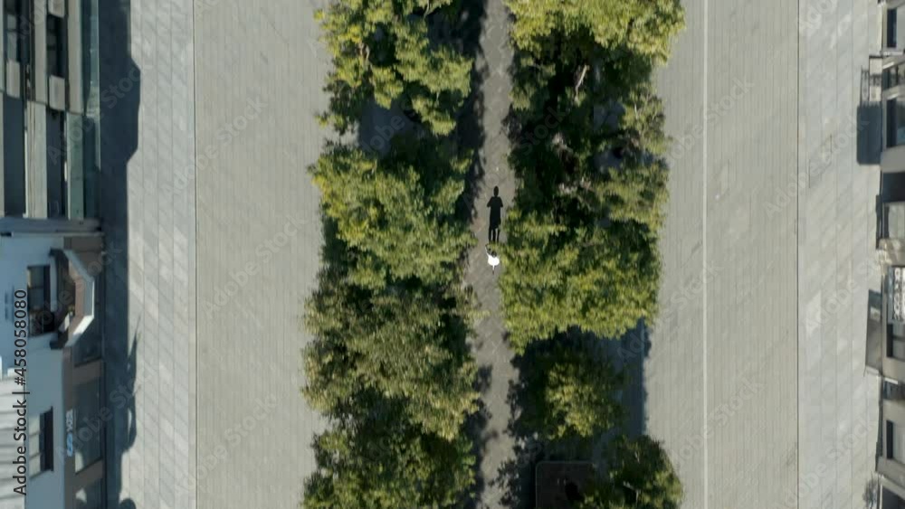 Aerial drone camera view of bike rider cycling through the city between ...