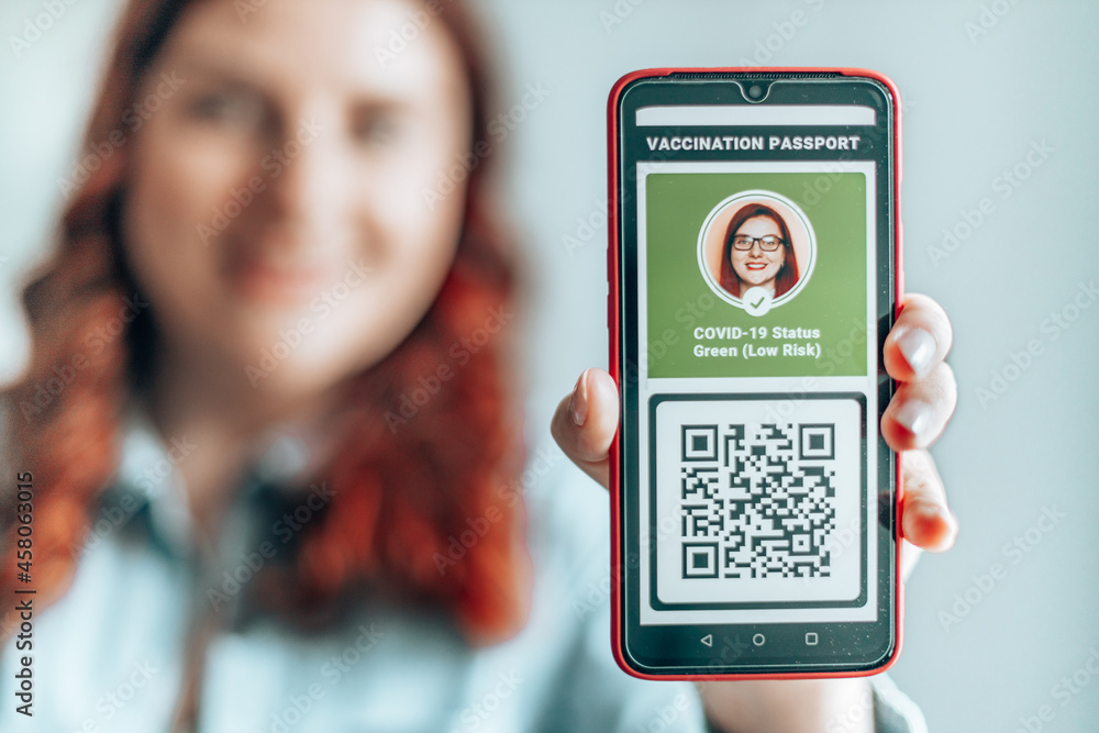 immunization certificate. Young girl wearing face mask holding a ...