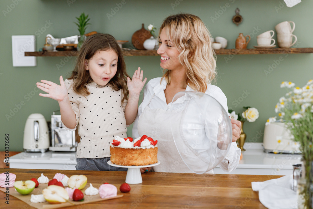 Happy chef cook baker mom woman in white shirt work with amazed baby ...