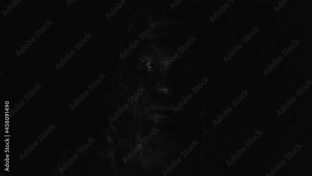 Stockvideo A scary man with black painted face staring into the camera ...