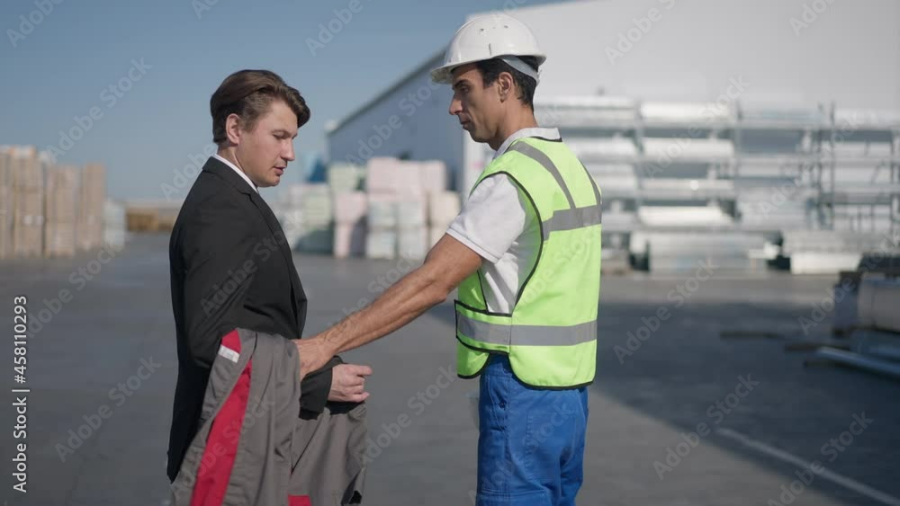 Side view of angry overwhelmed Middle Eastern man passing uniform to ...
