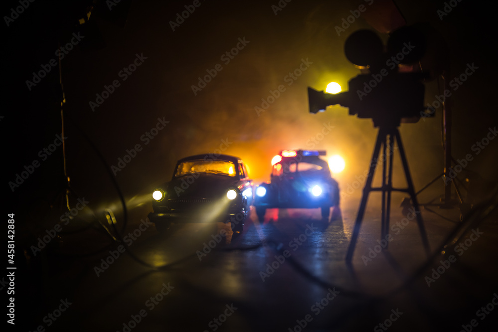 Action movie concept. Police cars and miniature movie set on dark toned ...