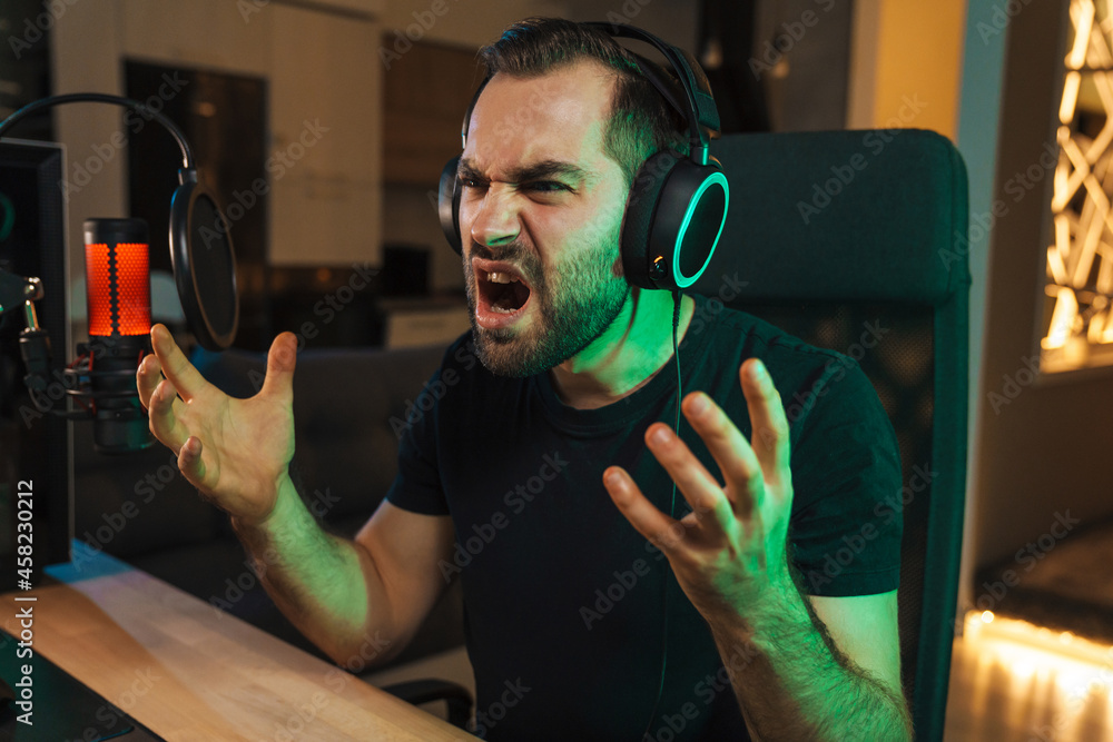 Angry young gamer playing game on computer Stock Photo | Adobe Stock
