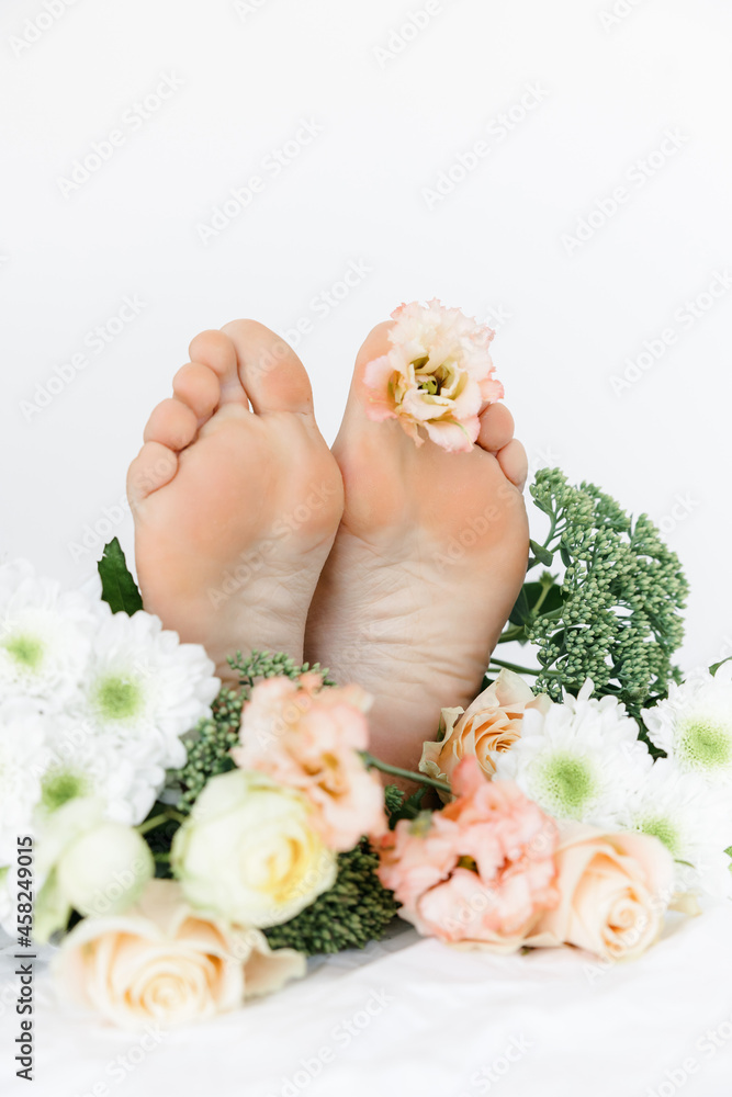 Foto de women's feet in fresh flowers. Summer lifestyle portrait of the ...