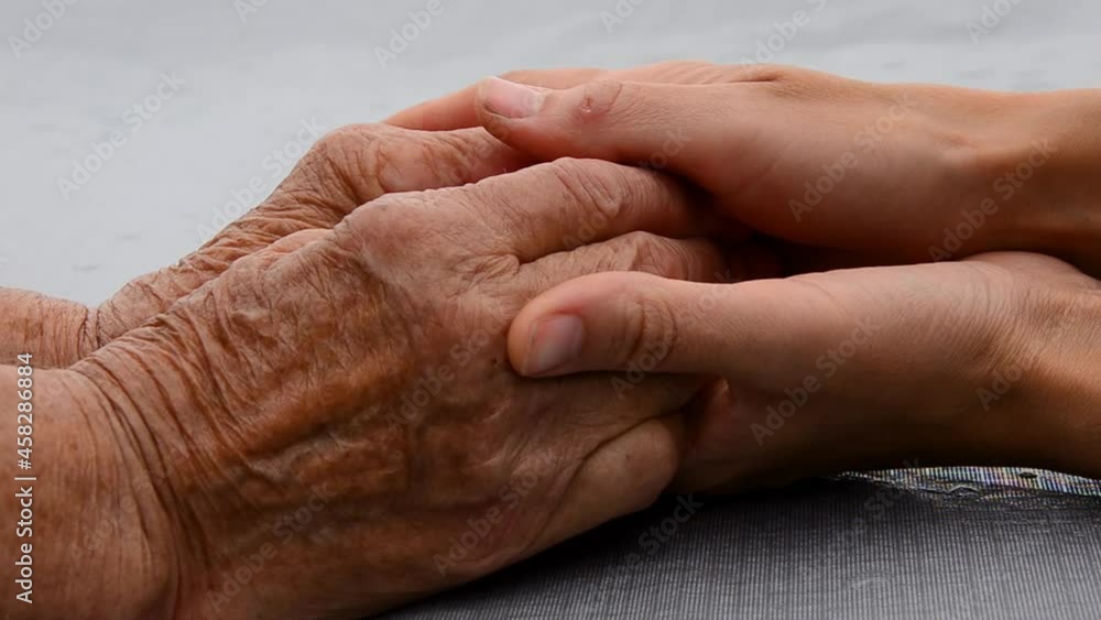 Old and young hands are held together. Grandmother's wrinkled hands ...