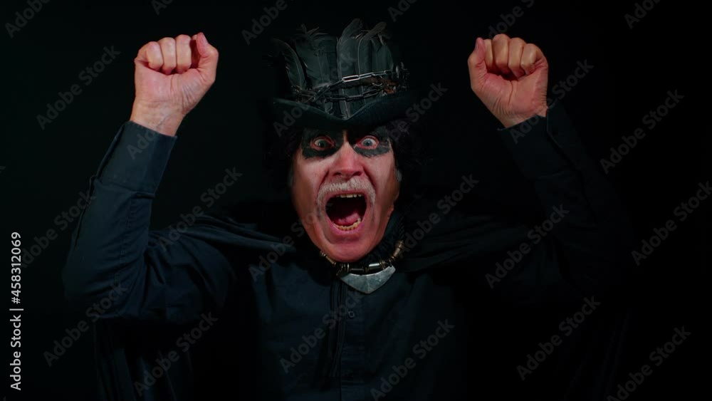Sinister old man in costume of Halloween witcher screams from stress ...
