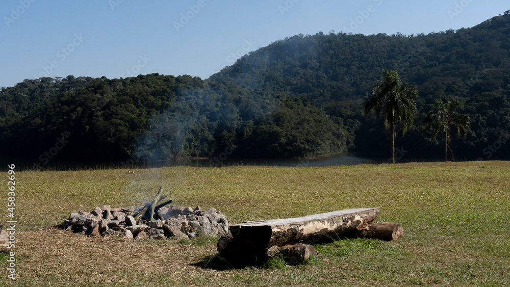 Fogueira quase apagada durante o dia com fumaça sendo expelida em ...