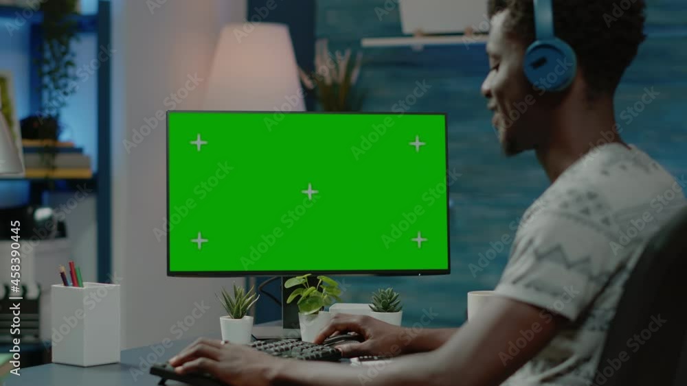 Adult looking at horizontal green screen on computer for work. Employee ...